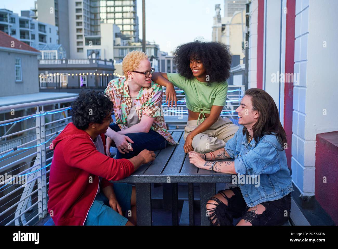 Happy young friends hanging out on urban balcony Stock Photo - Alamy