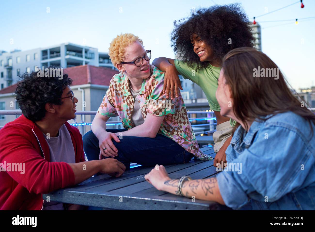 Young friends talking, hanging out on urban balcony Stock Photo - Alamy