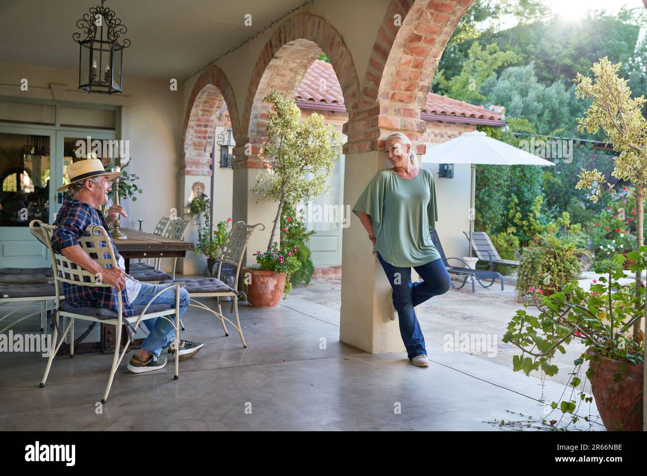 Happy senior couple talking on summer villa patio Stock Photo - Alamy