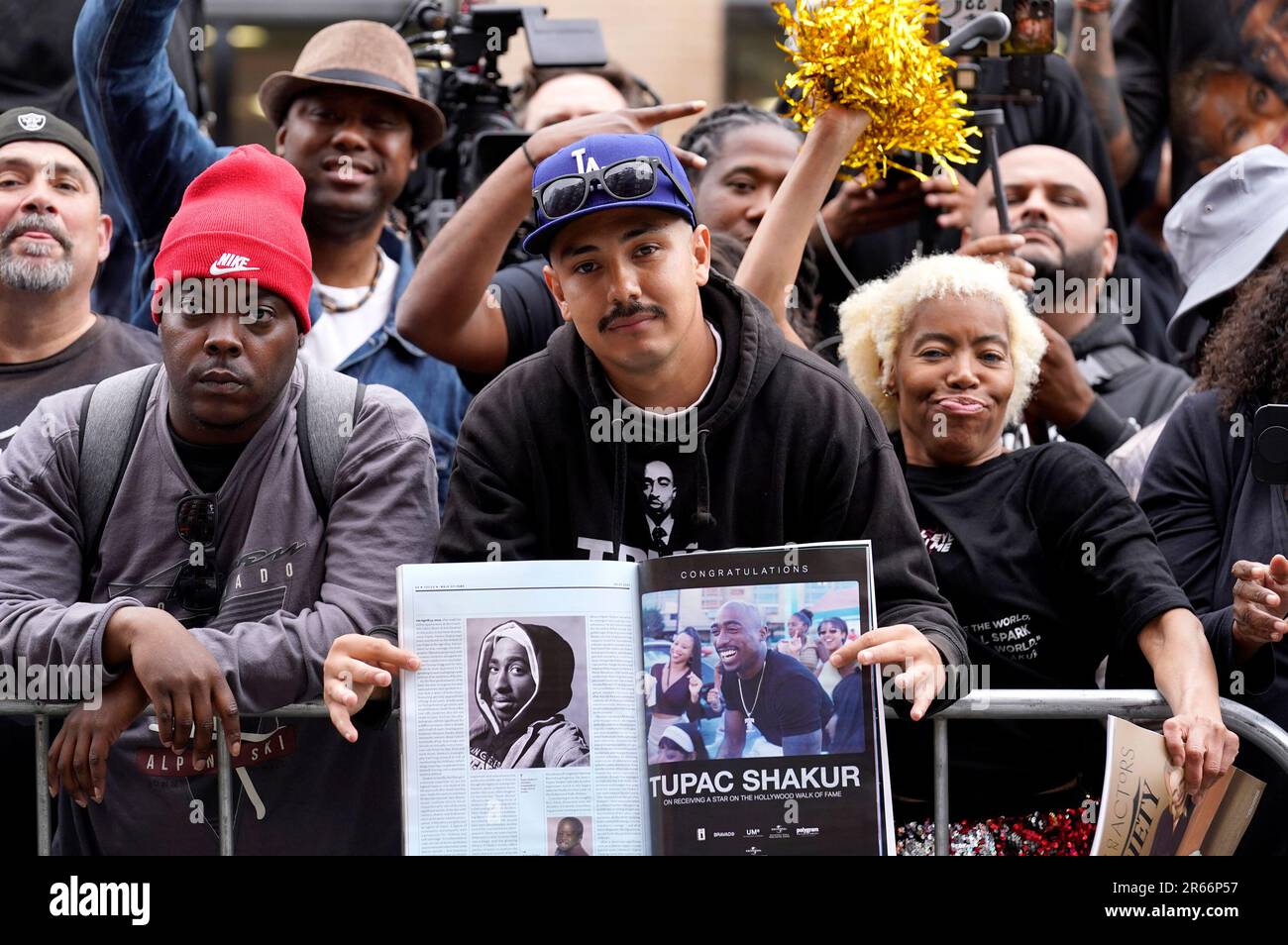 A fan displays an image from a book of late rapper and actor Tupac ...