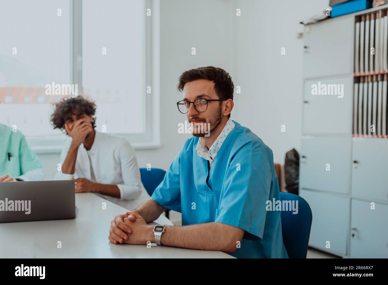 A doctor leading a meeting of the medical team in a modern medical room ...