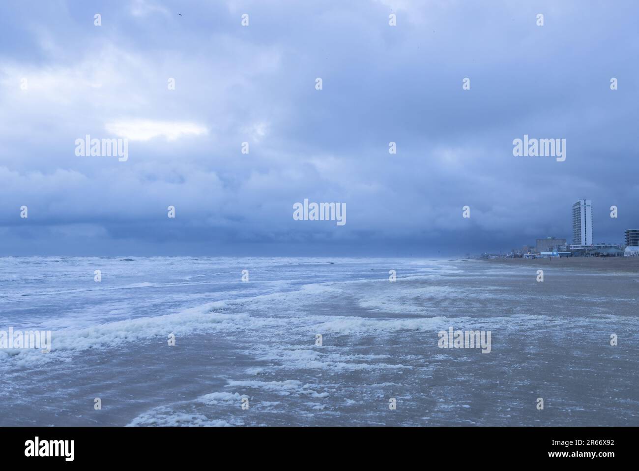 Seascape, beach, gloomy gray sky, surf and urban high-rise buildings in ...