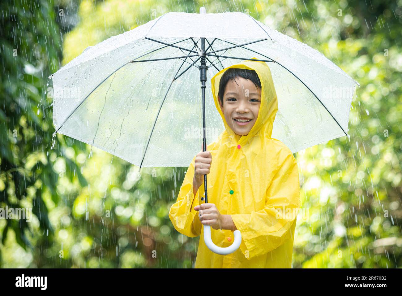 Portrait Asian kid holding an umbrella with raindrops. Happy Asian ...