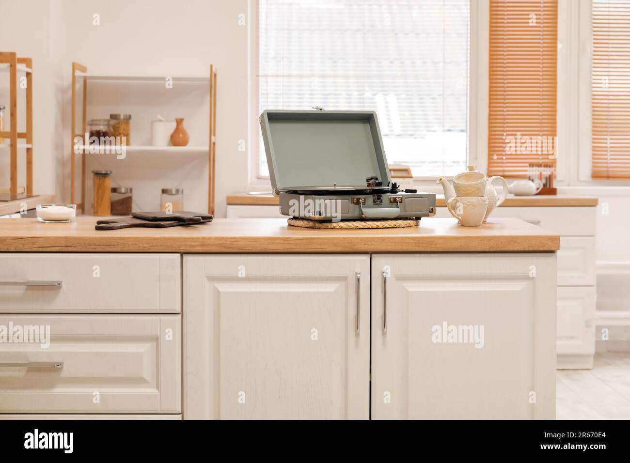 Record player with vinyl disk, cups and teapot on counter in kitchen ...