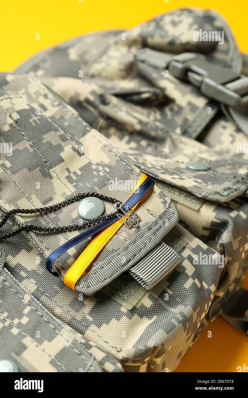 Chain with Ukrainian coat of arms, ribbons and military bag on yellow ...