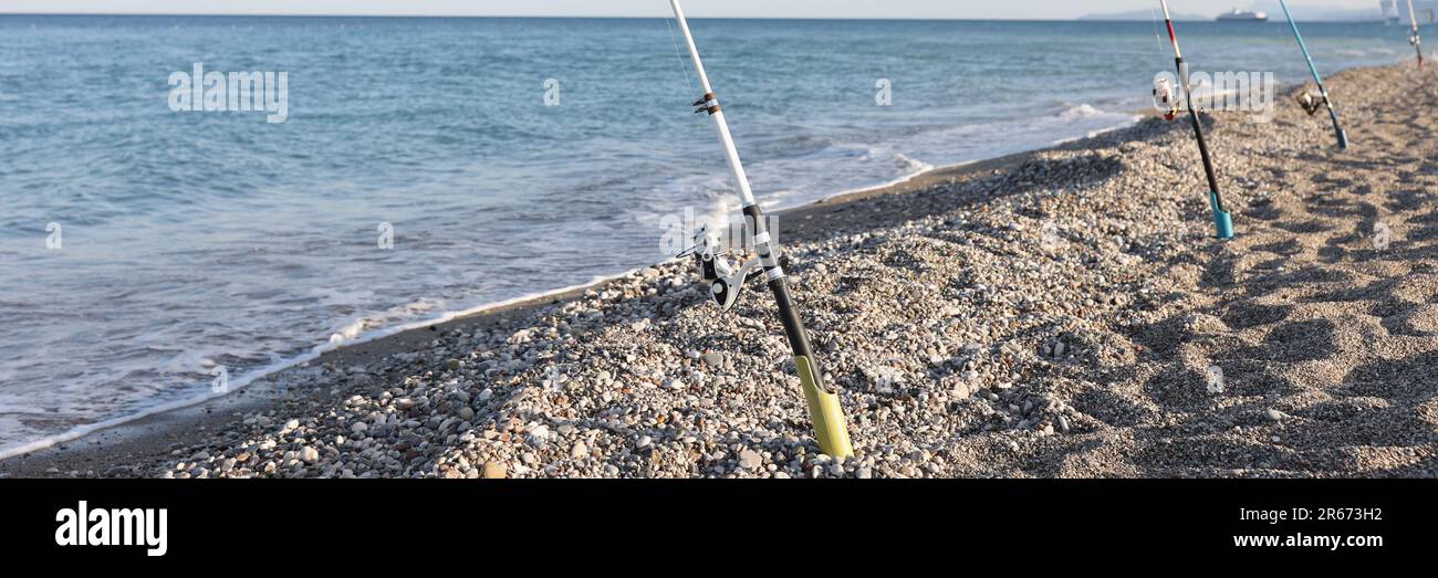 Fisherman setting up fishing rods on sea beach, seaside landscape Stock ...