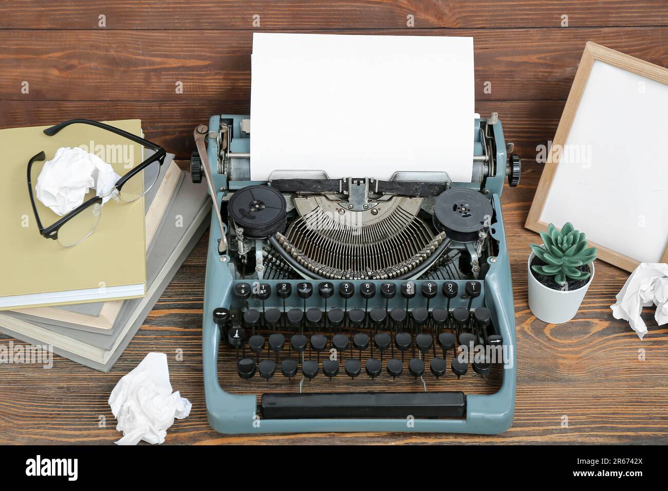 Vintage typewriter with books, empty frame and eyeglasses on brown ...