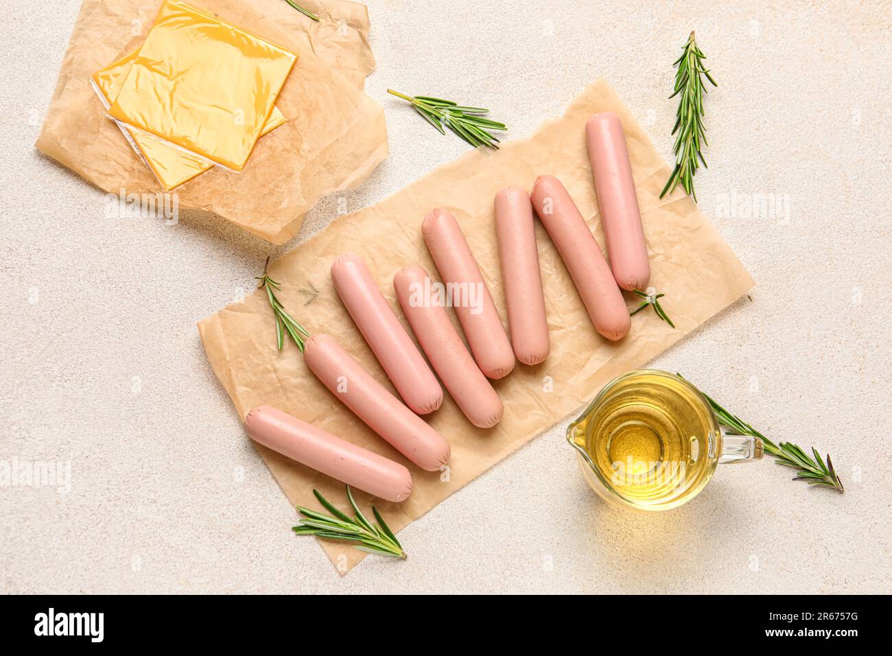 Baking paper with tasty thin sausages and cheese on white background ...