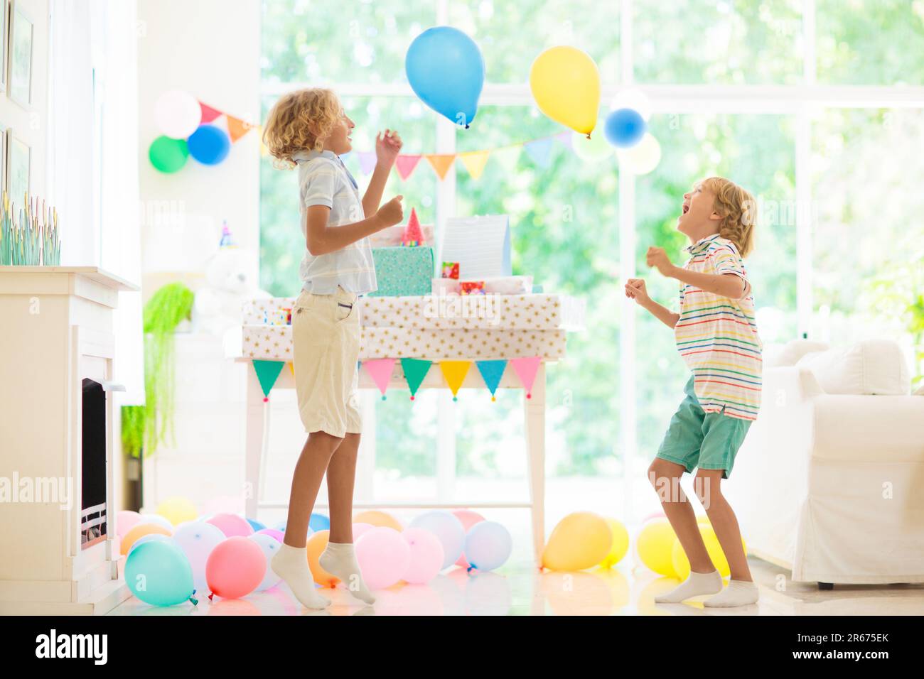 Kids birthday party. Children play with balloons and open presents ...