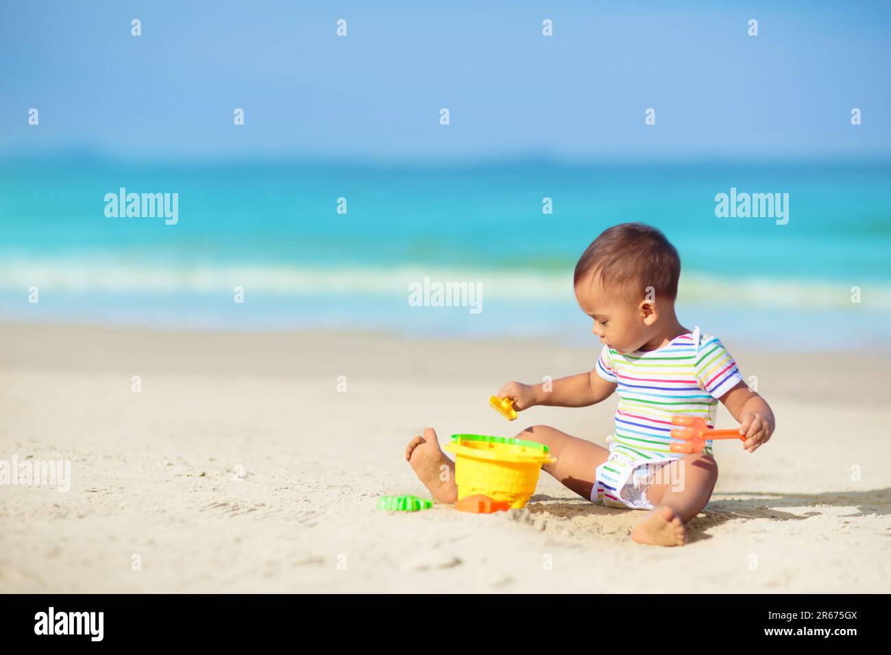 Baby playing on tropical beach. Children play at sea on summer family ...