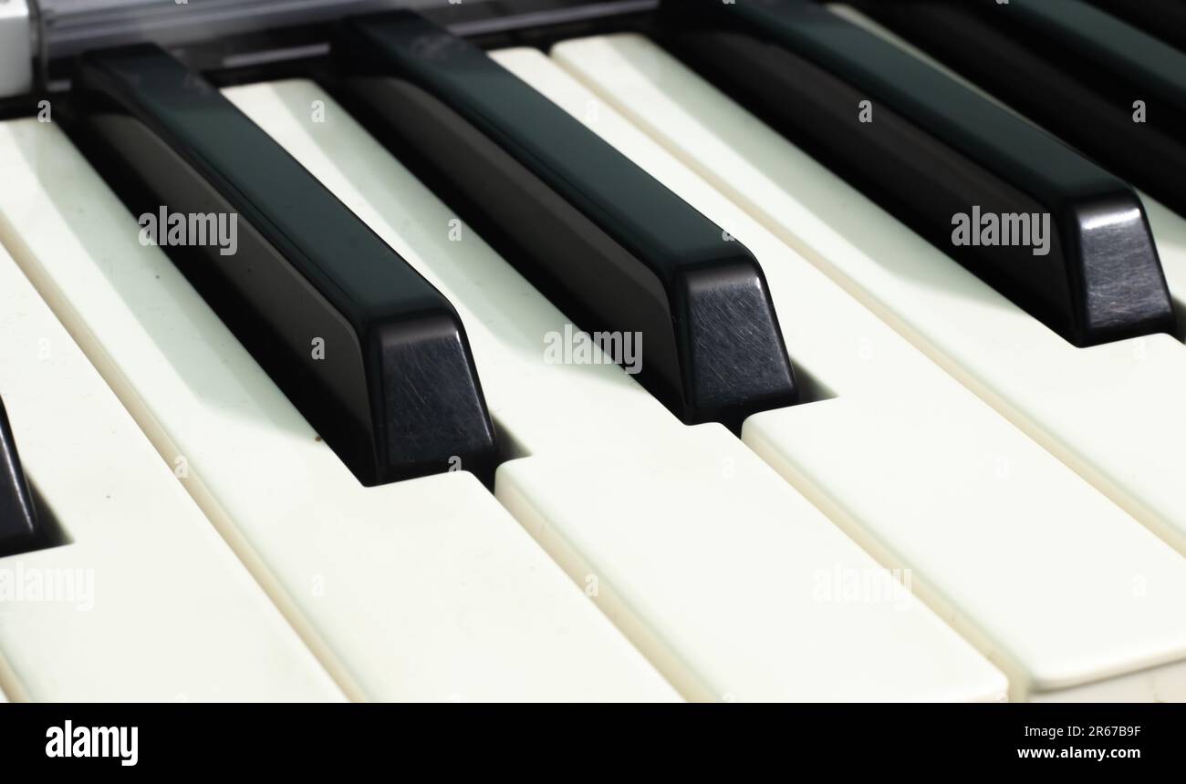 A close-up image of a piano keyboard with a microphone placed on top ...