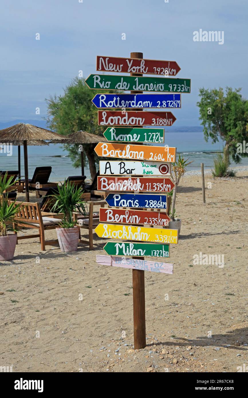 Signpost to exotic destinations at a beach bar, Agistri island, Saronic ...