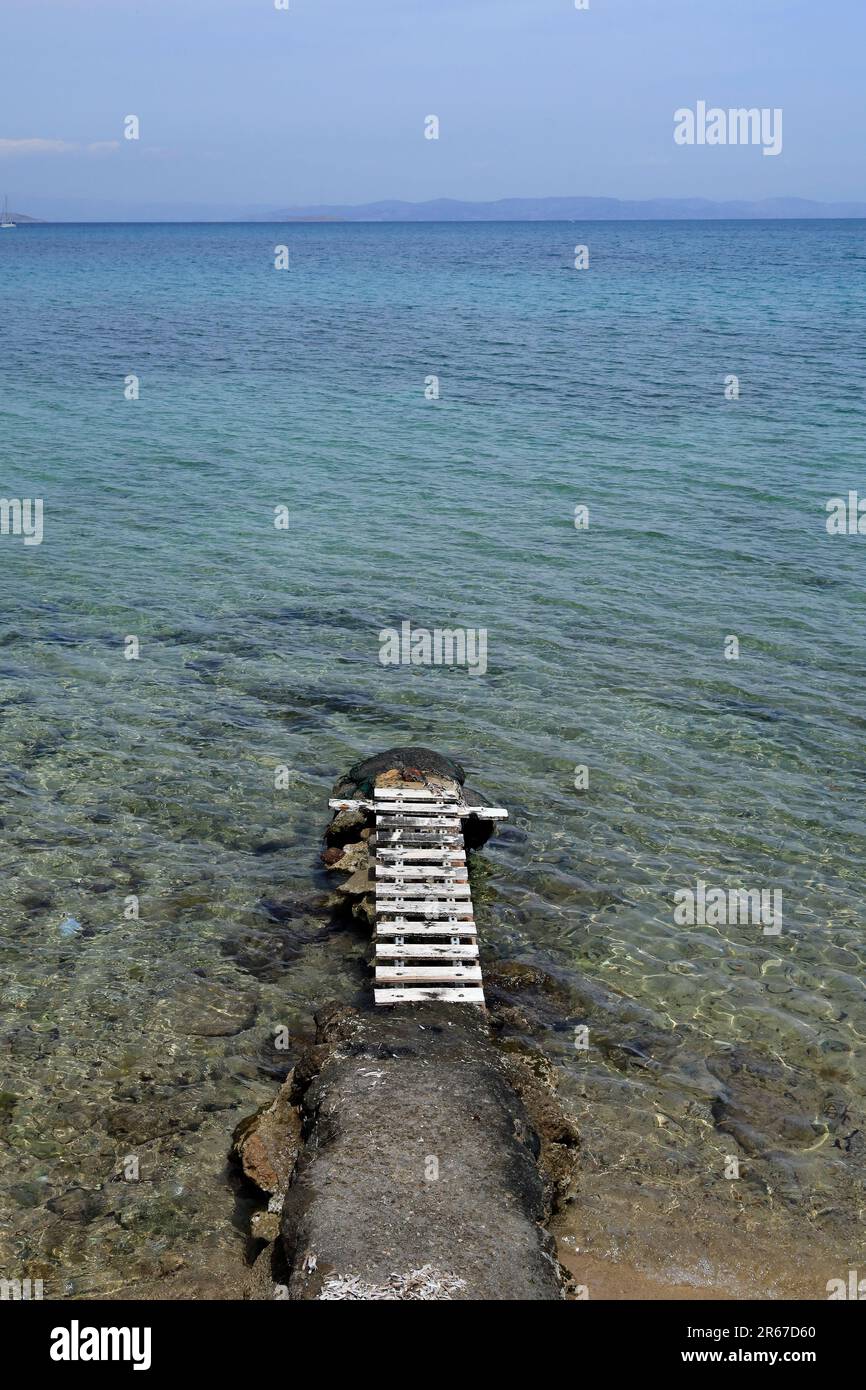 Small old wooden jetty leading the eye to the horizon, Agistri island ...