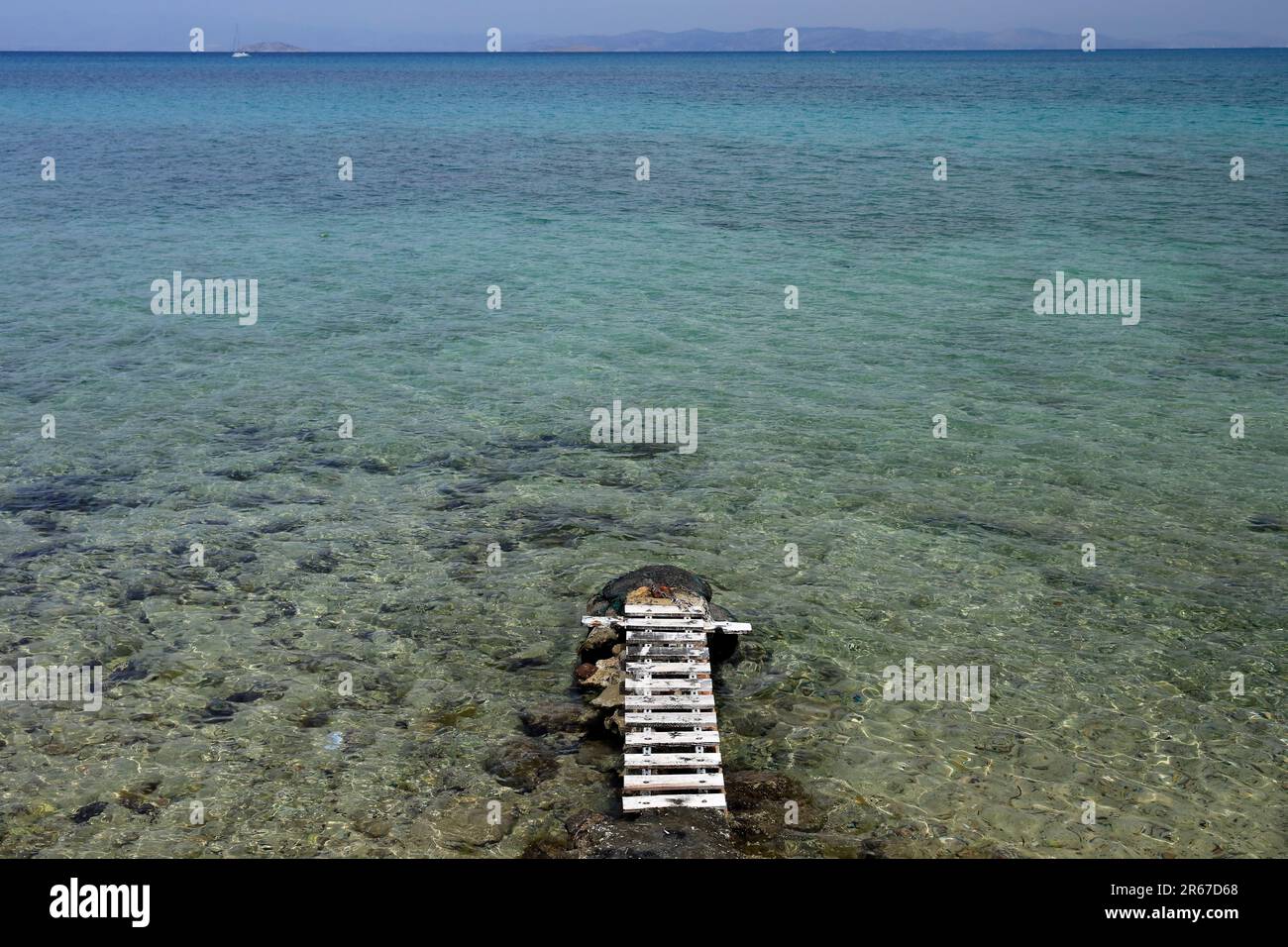 Small old wooden jetty leading the eye to the horizon, Agistri island ...