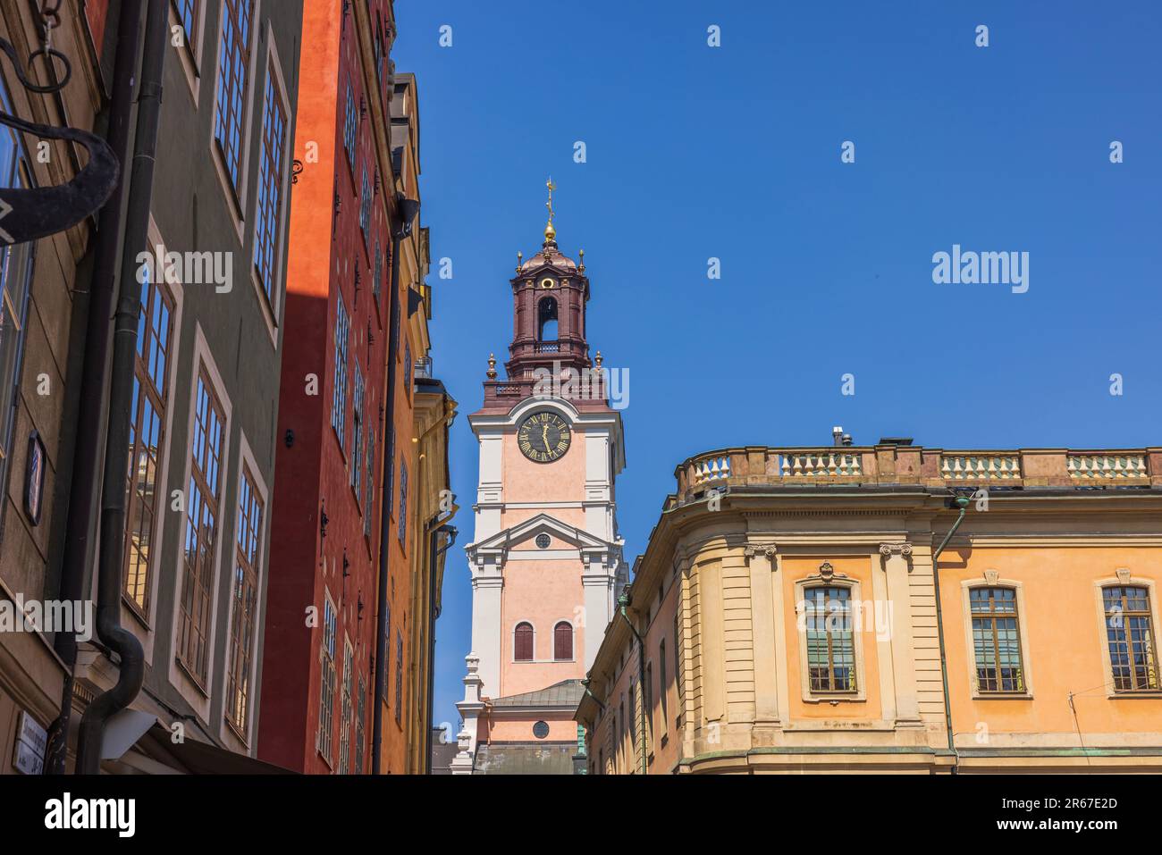 View up to roofs of old buildings. Big wall clock on tower of building ...