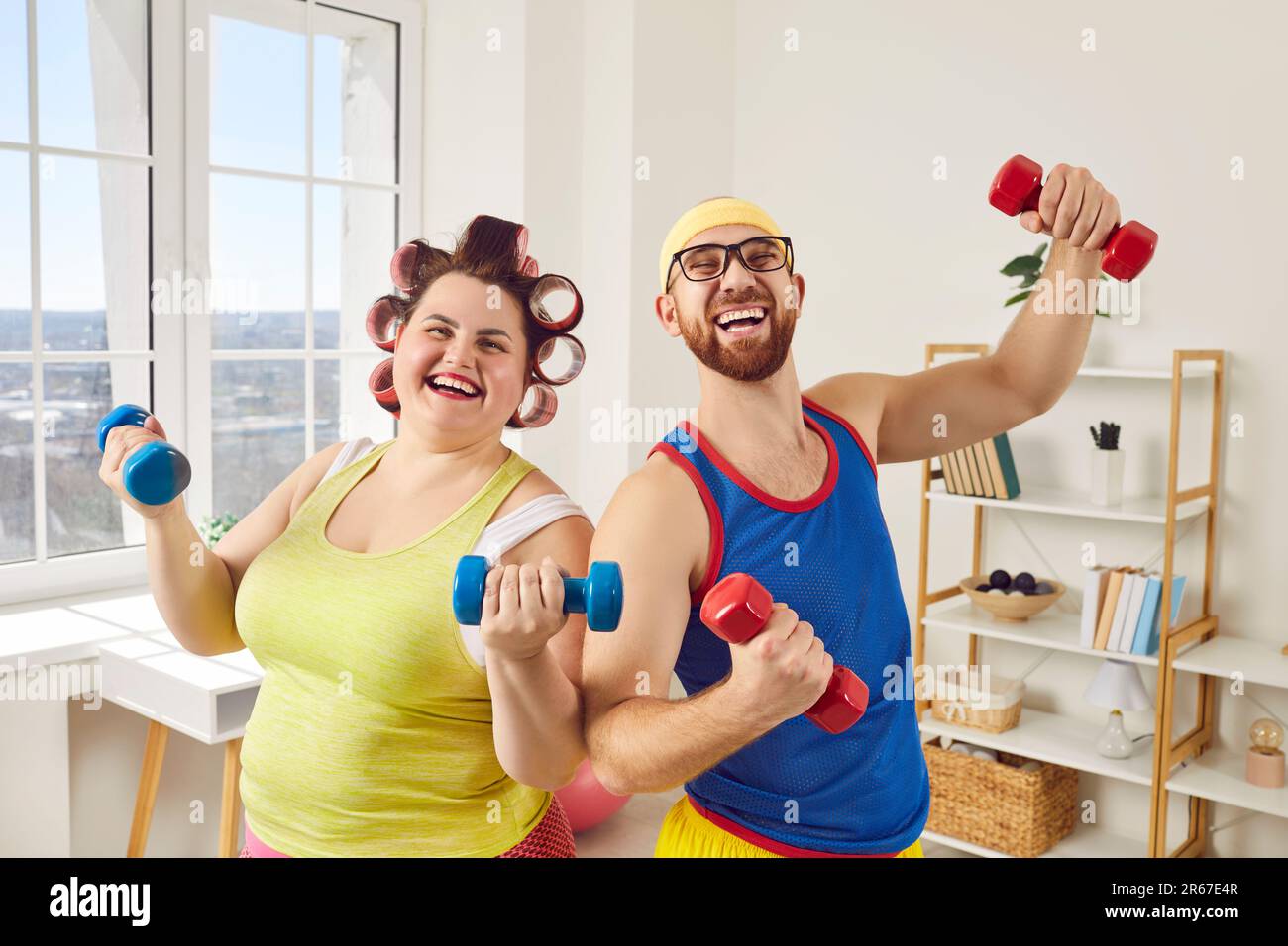 Funny overweight fat woman with bearded man in bright sportswear doing ...