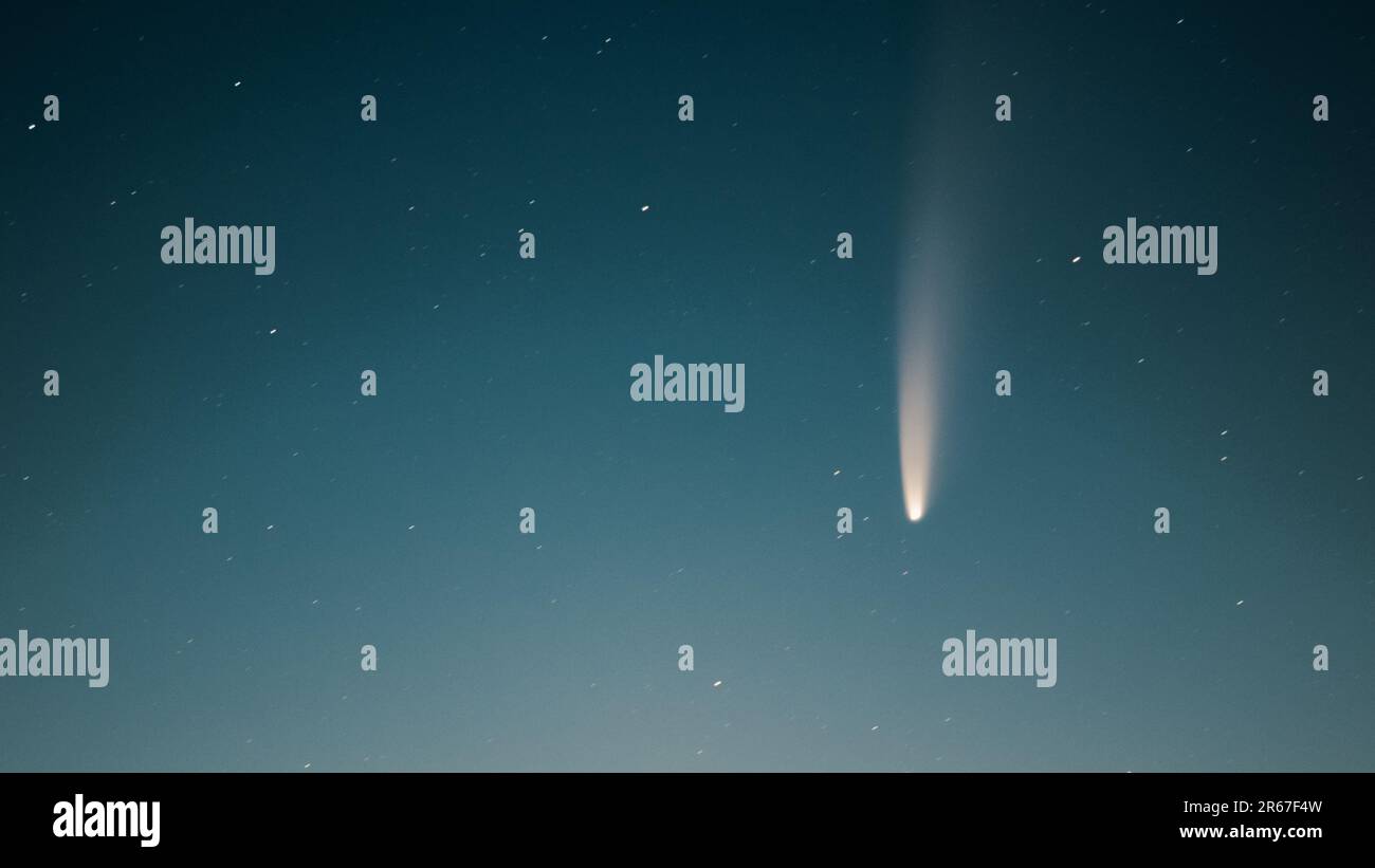 An awe-inspiring shot of a comet streaking across a star-studded night ...