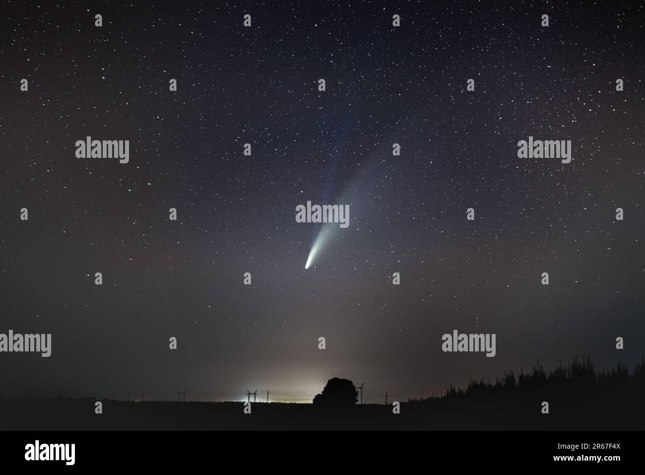 An awe-inspiring shot of a comet streaking across a star-studded night ...