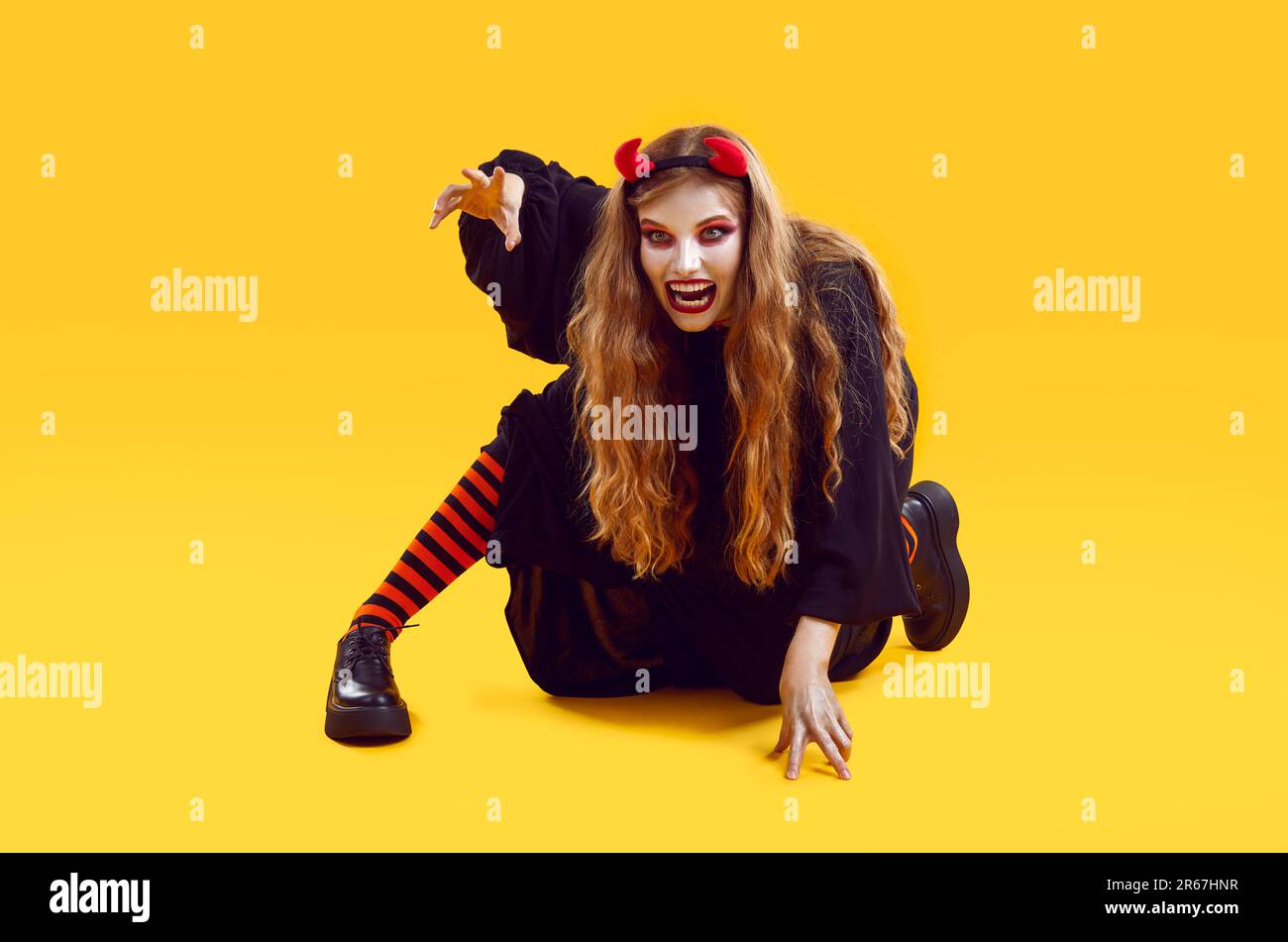 Scary woman with open mouth dressed as devil for Halloween crawling and ...