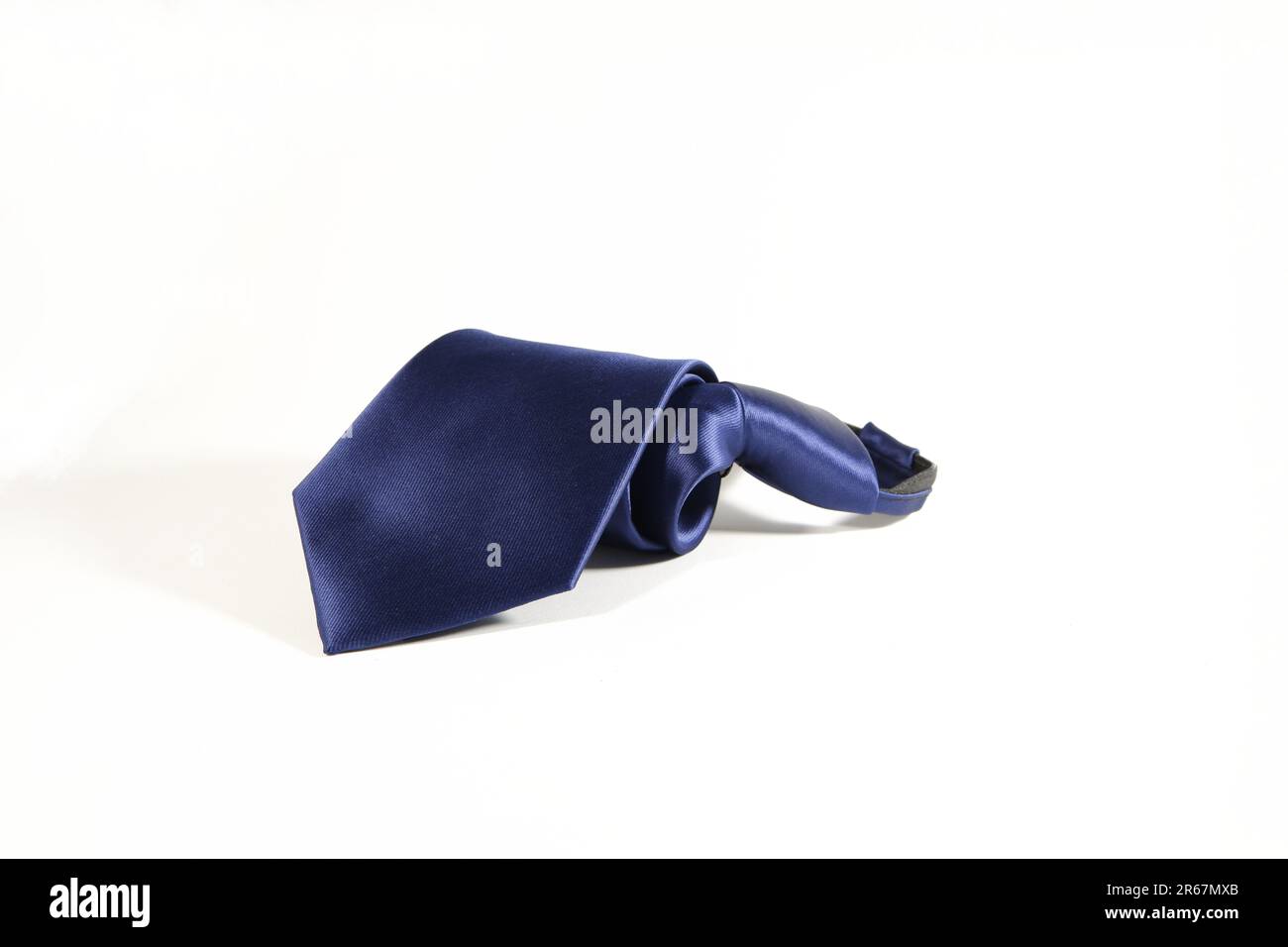 An isolated image of a men's blue necktie resting on a white background ...