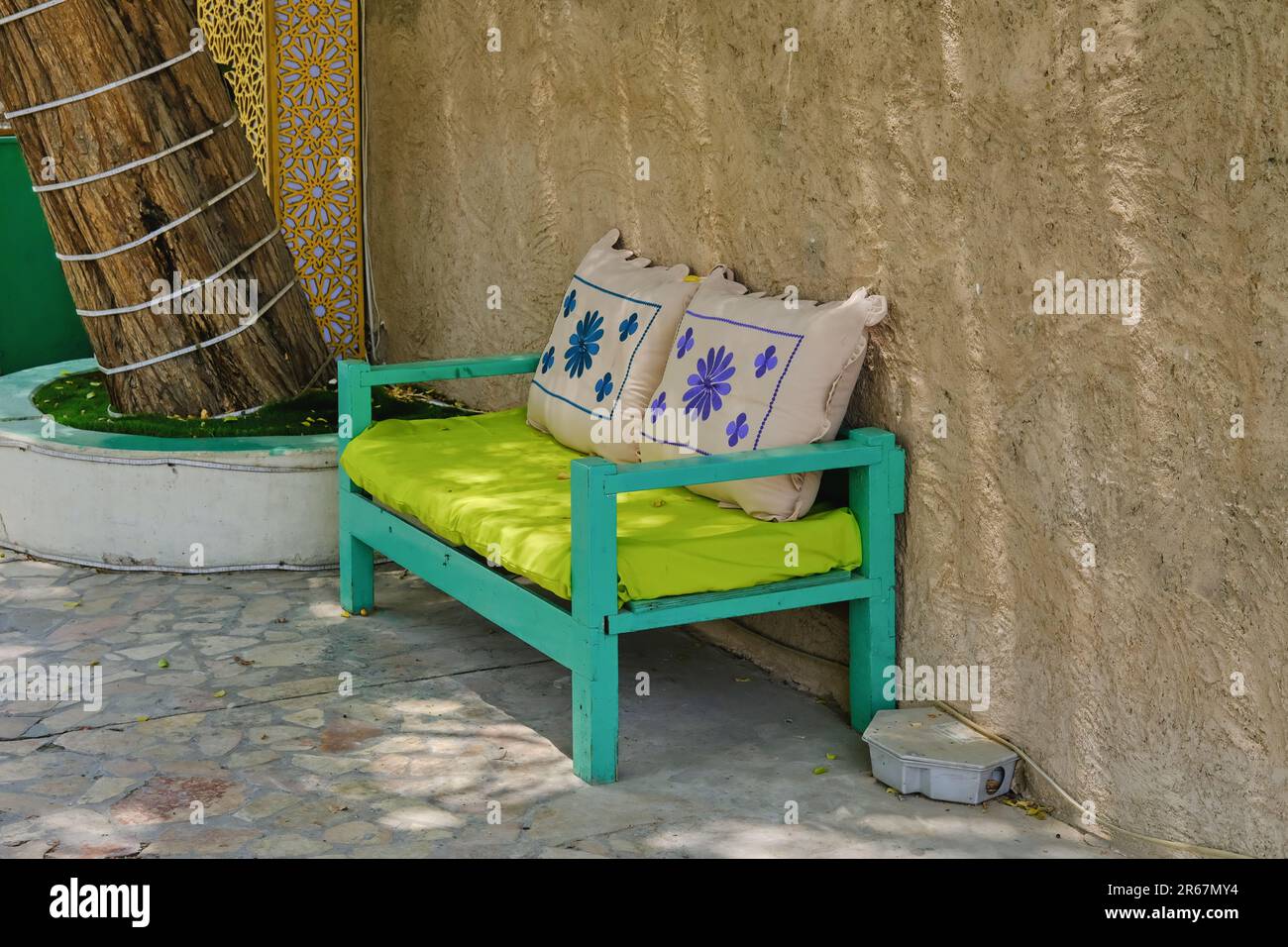 View of traditional painted wooden bench with decorative fabric ...