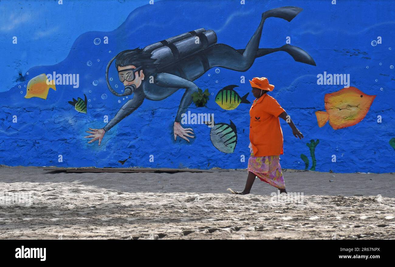 Mumbai, India. 21st May, 2023. A beach cleaning staff walks past a ...