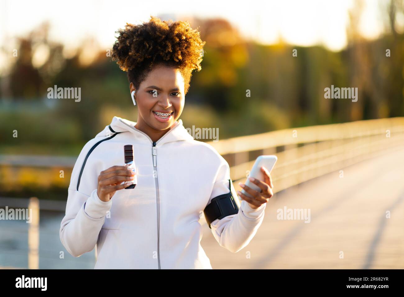 Calorie Counter App. Smiling Black Woman Using Smartphone And Eating ...