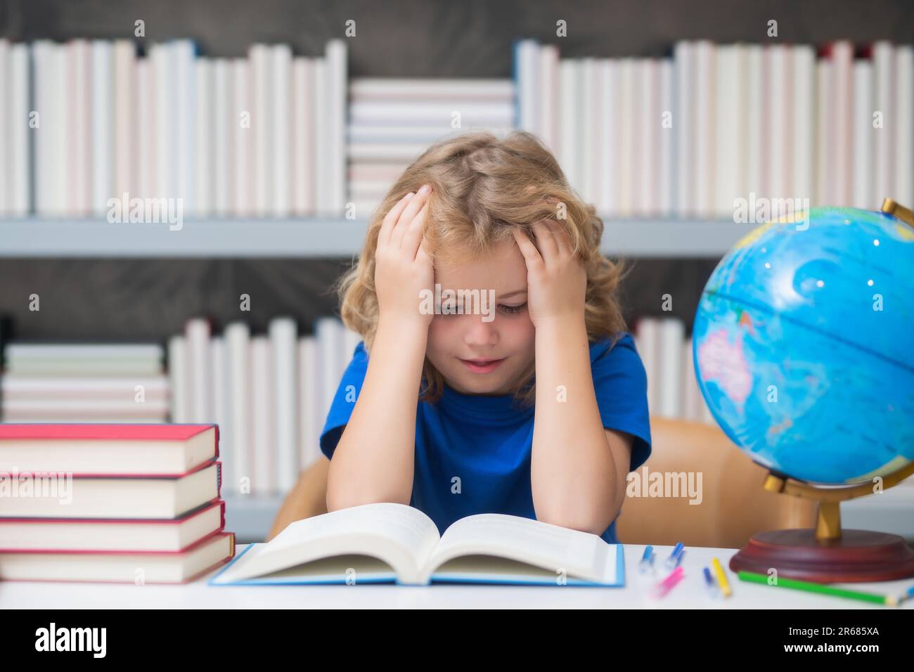Tired school boy, bored pupil at school. School child pupil reading ...