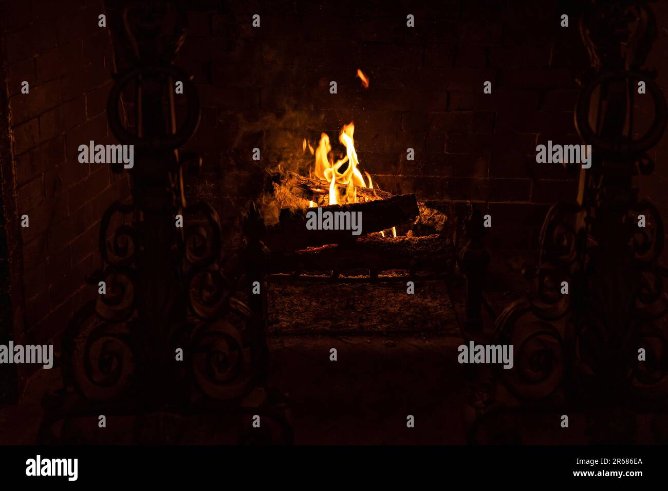 A roaring indoor fire with orange flames in a wood burning fireplace ...