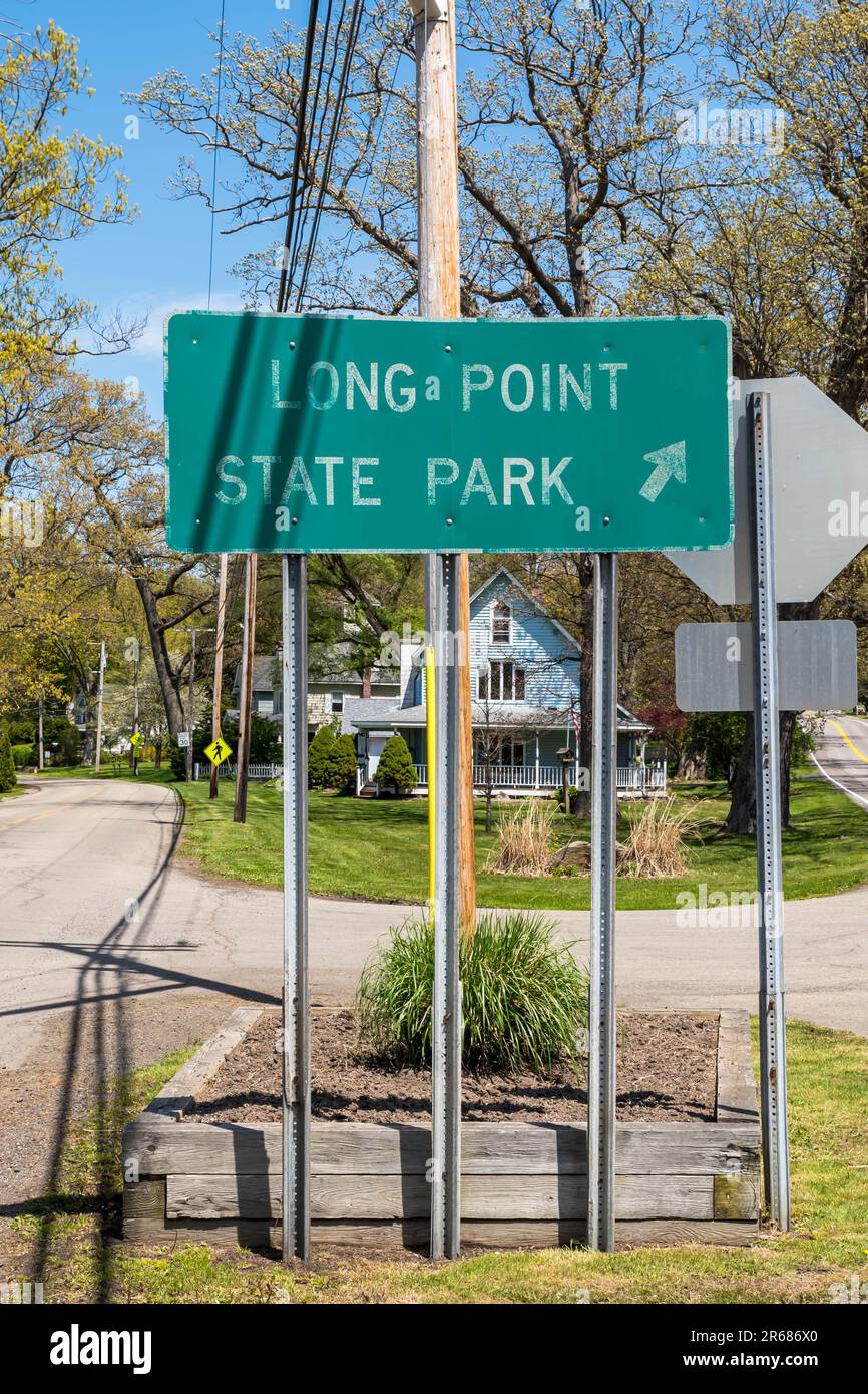 A faded and weathered sign for the Long Point State Park at a Y in the ...