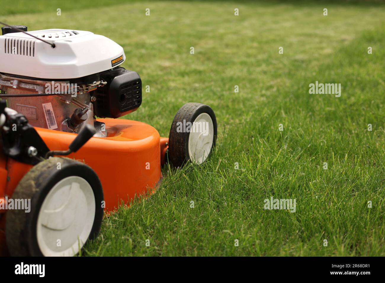 Gardening work tools. Close up details of orange electric lawn mower ...