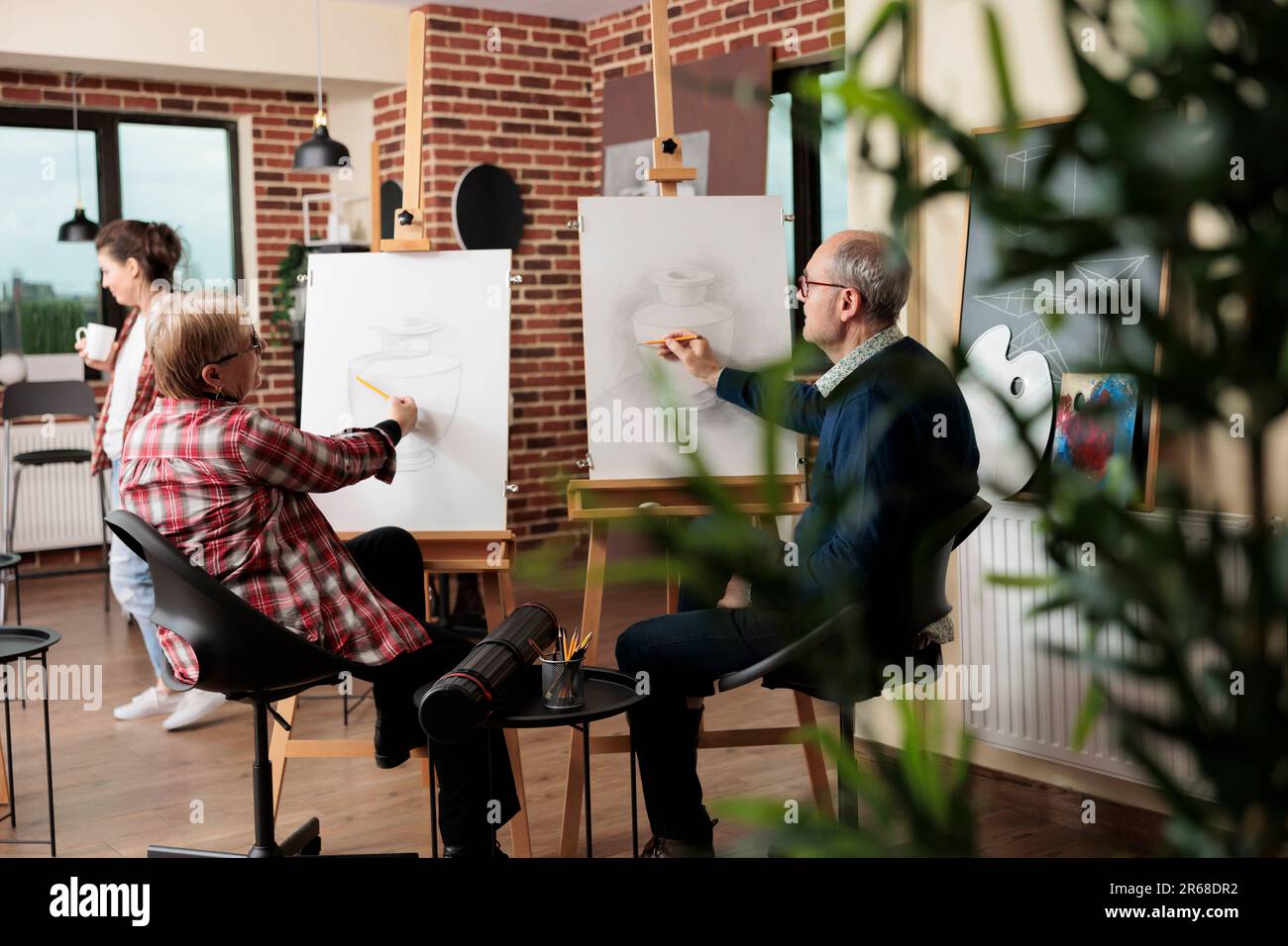 Mature couple man and woman learning drawing at group art class in ...