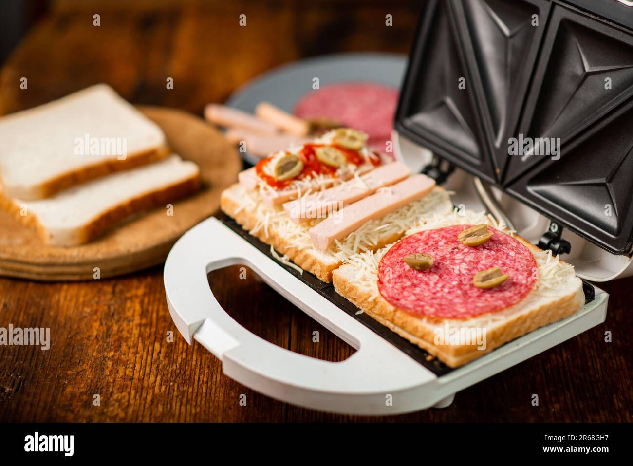 sandwich maker and cooking different sandwiches with sausage, cheese ...