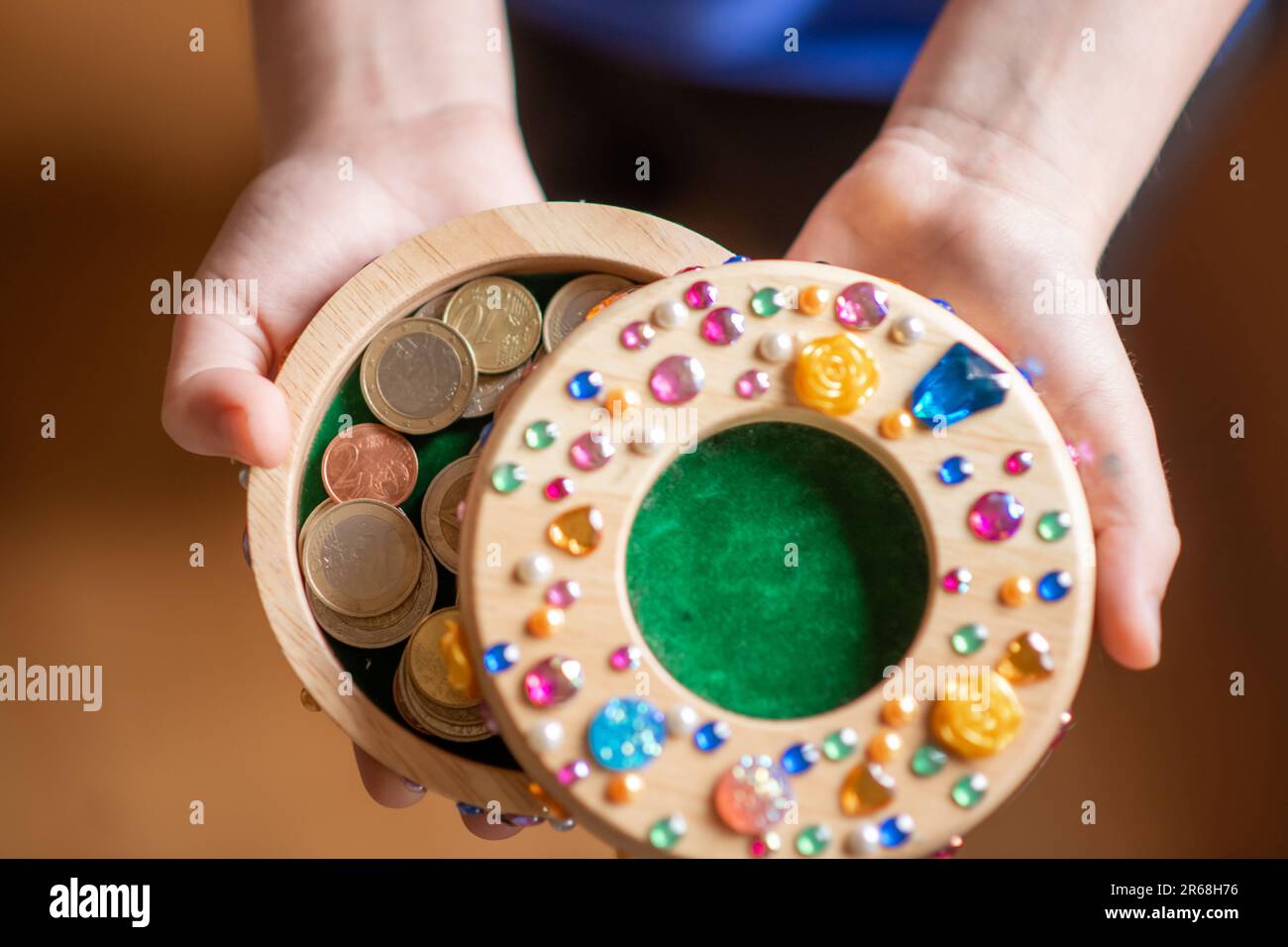 Children's homemade piggy bank with euro cents in the hands of a child ...