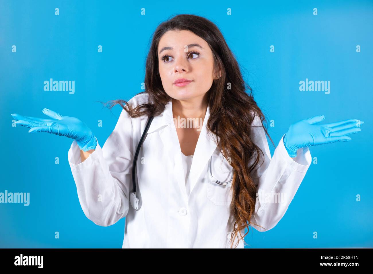 Brown-haired doctor in gloves and with stethoscope looks around for ...