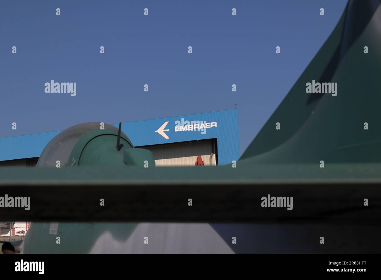 Partial view of a Supertucano plane in the foreground with the Embraer ...