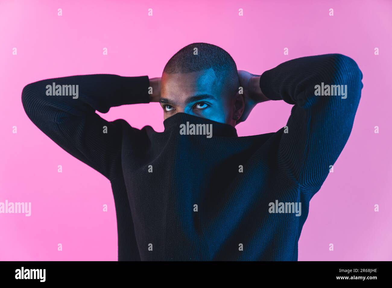 Young black male model with half face covered in black sweater. Hands ...