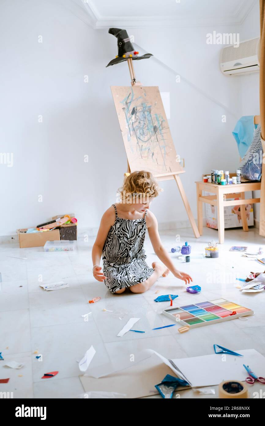 Creative mess in kids room. Talented child girl playing with play dough ...
