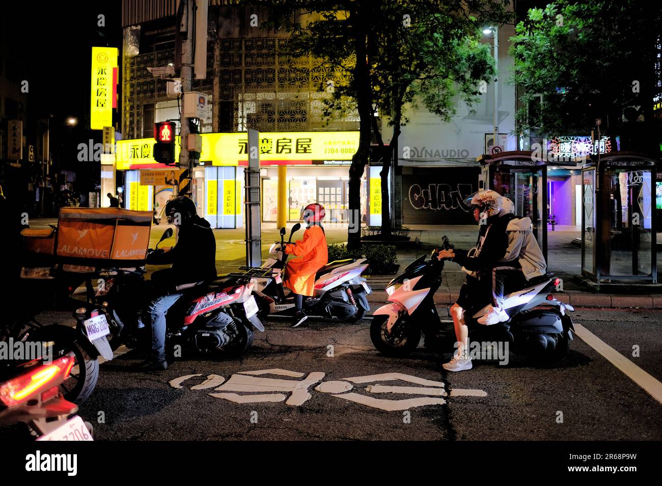 Scooters and riders at a traffic stop on a designated scooter lane in ...