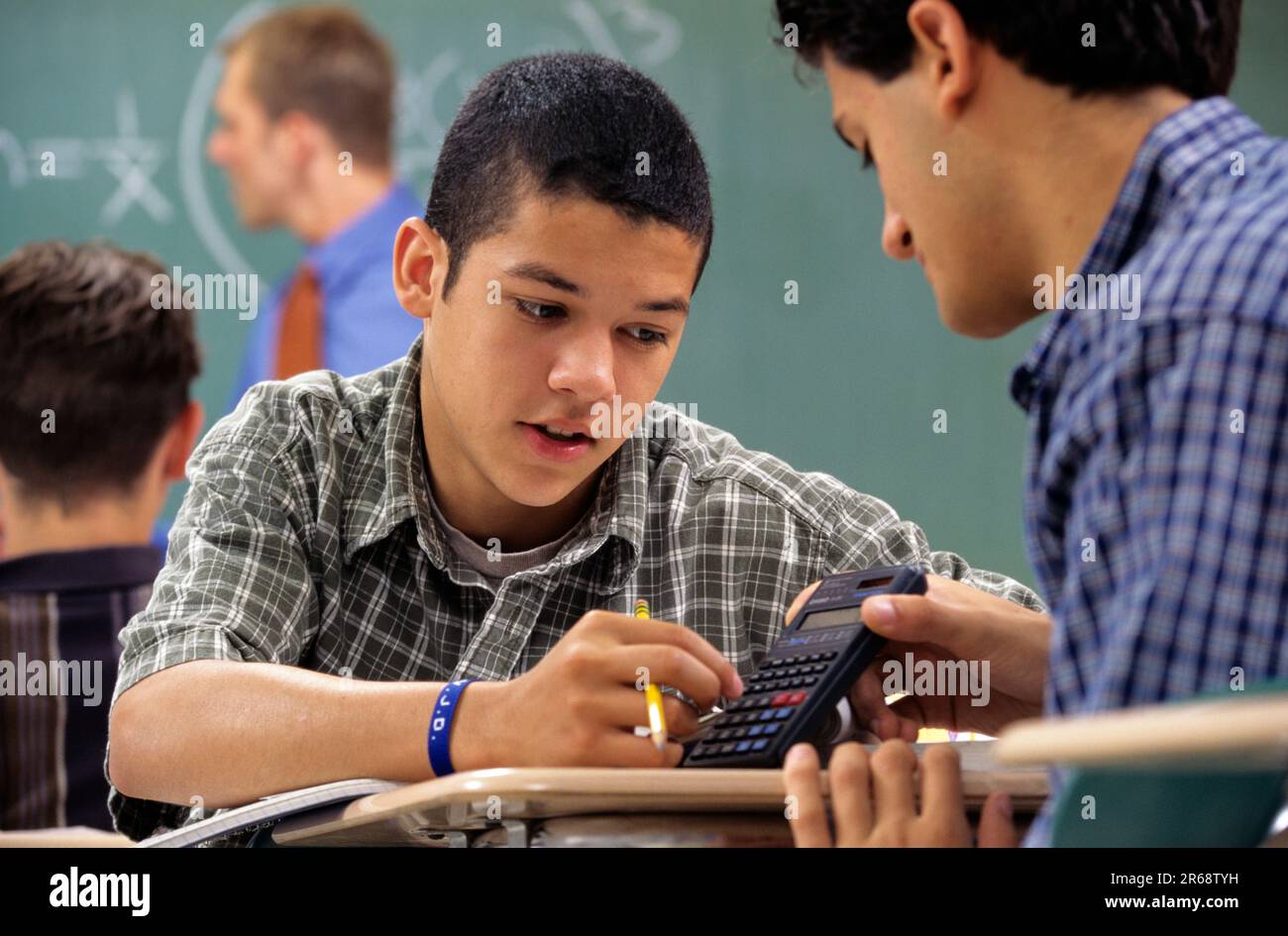 two students work with a calculator on a project in math class Stock ...