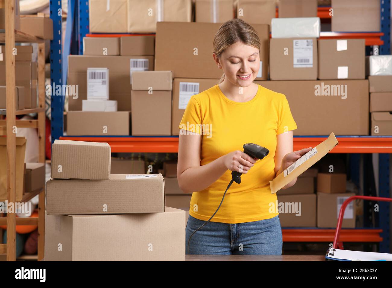 Post office worker with scanner reading parcel barcode indoors Stock ...