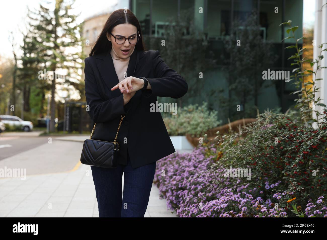Emotional woman checking time on watch outdoors. Being late concept ...