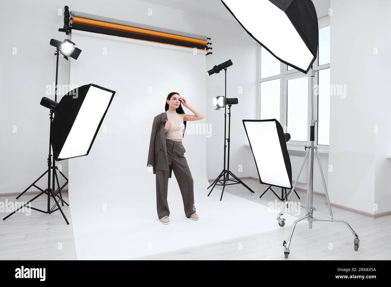 Beautiful young model posing in modern studio. Professional photo ...