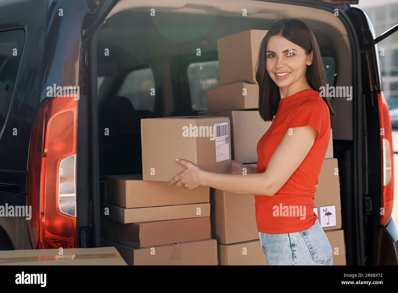 Courier taking parcel from delivery van outdoors Stock Photo - Alamy