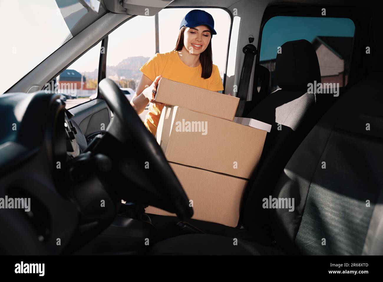 Courier taking parcel from car. Delivery service Stock Photo - Alamy