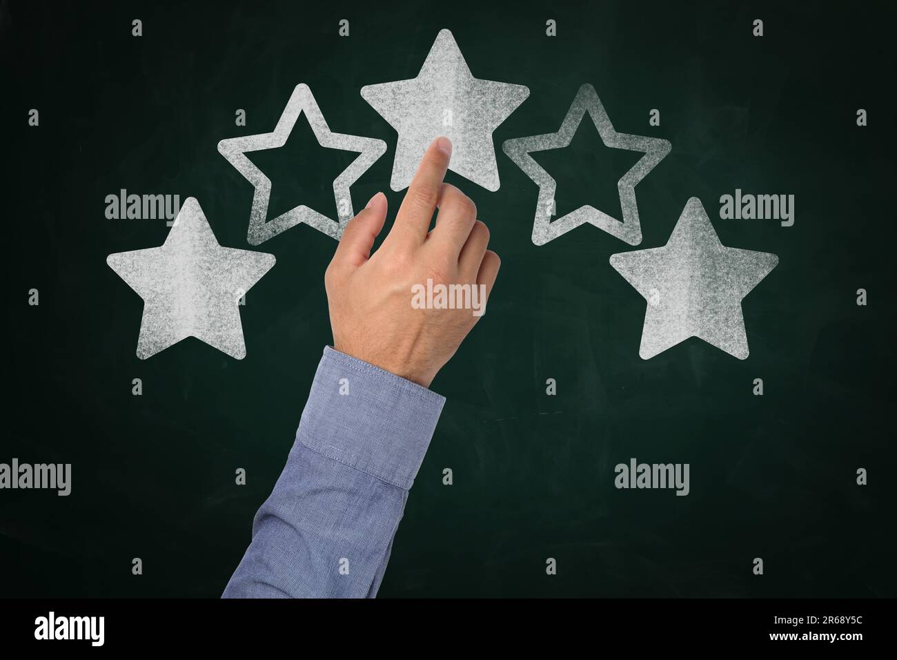 Quality rating. Man pointing at stars on chalkboard, closeup Stock ...