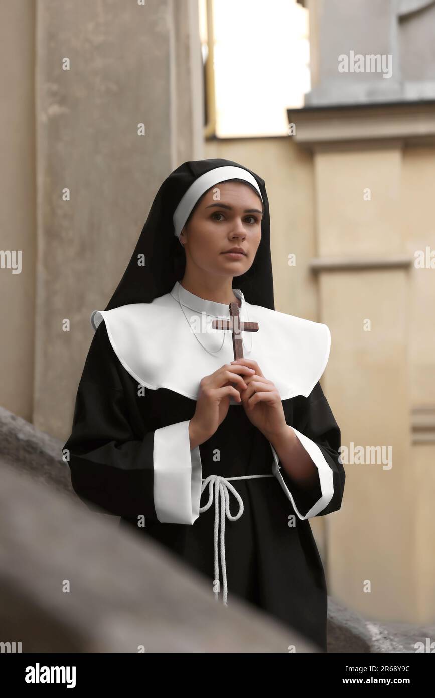 Young nun with Christian cross near building outdoors Stock Photo - Alamy