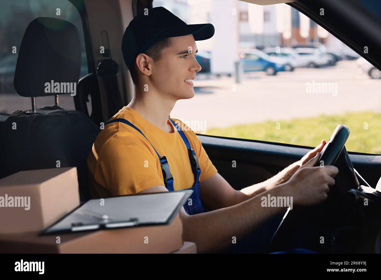 Courier with clipboard and parcels in car. Delivery service Stock Photo ...