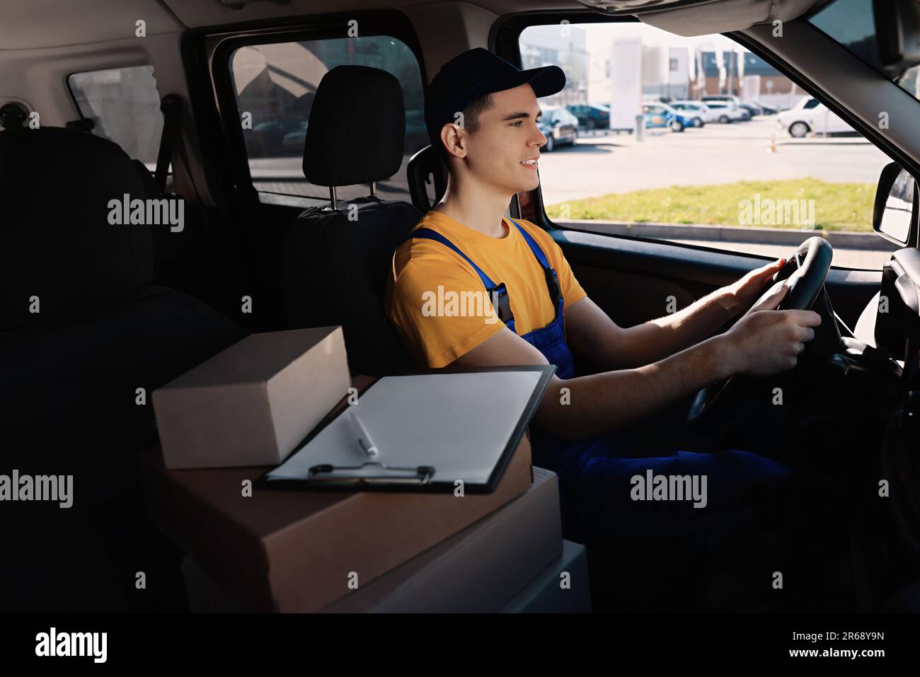 Courier with clipboard and parcels in car. Delivery service Stock Photo ...