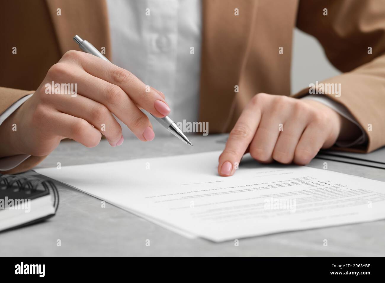 Woman signing document at light grey marble table, closeup Stock Photo ...